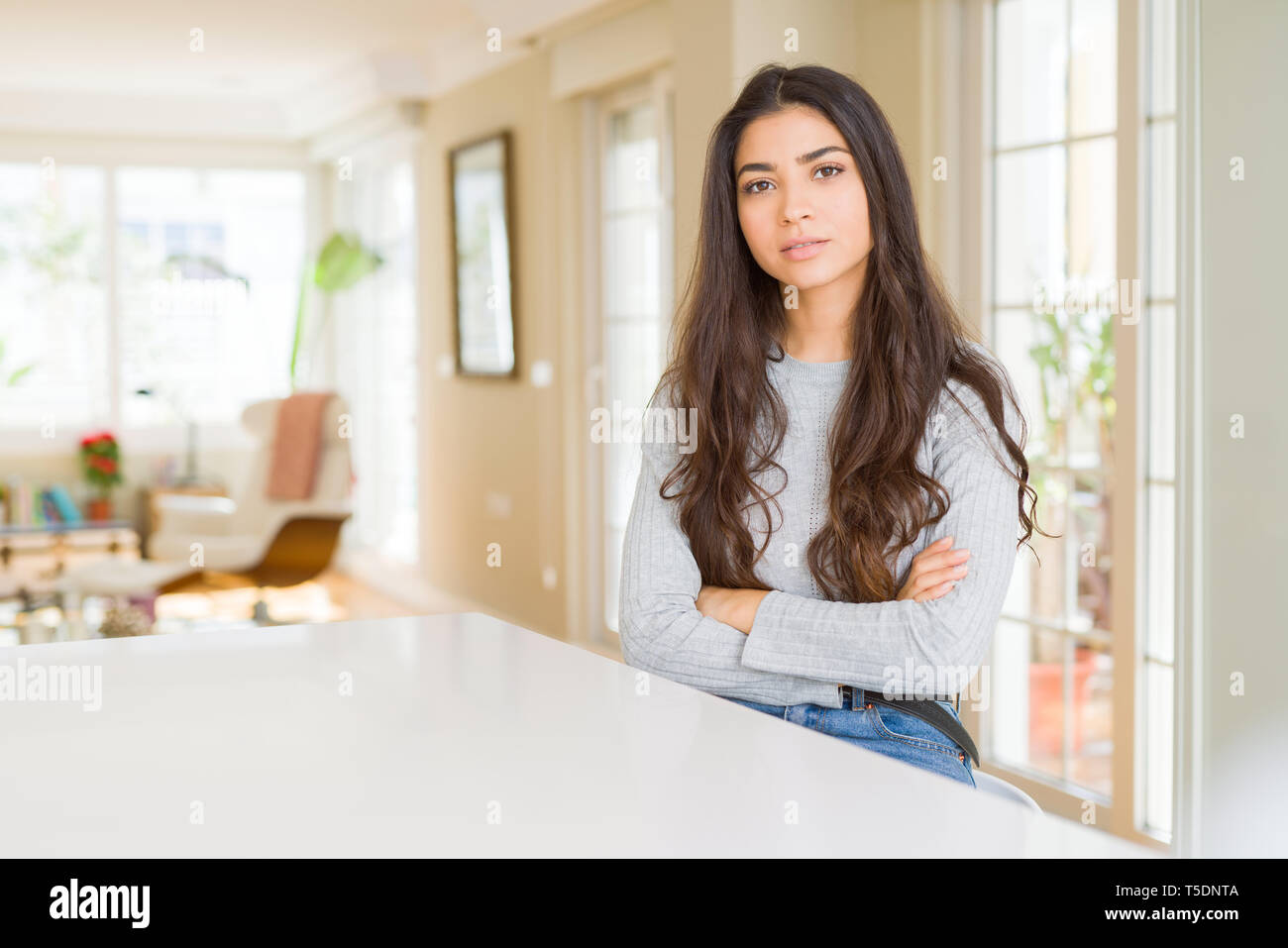 Young beautiful woman at home skeptic and nervous, disapproving ...