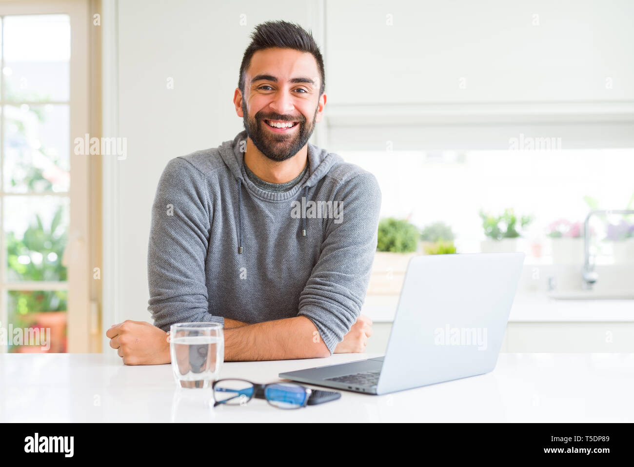 Handsome hispanic man working using computer laptop with a happy and ...