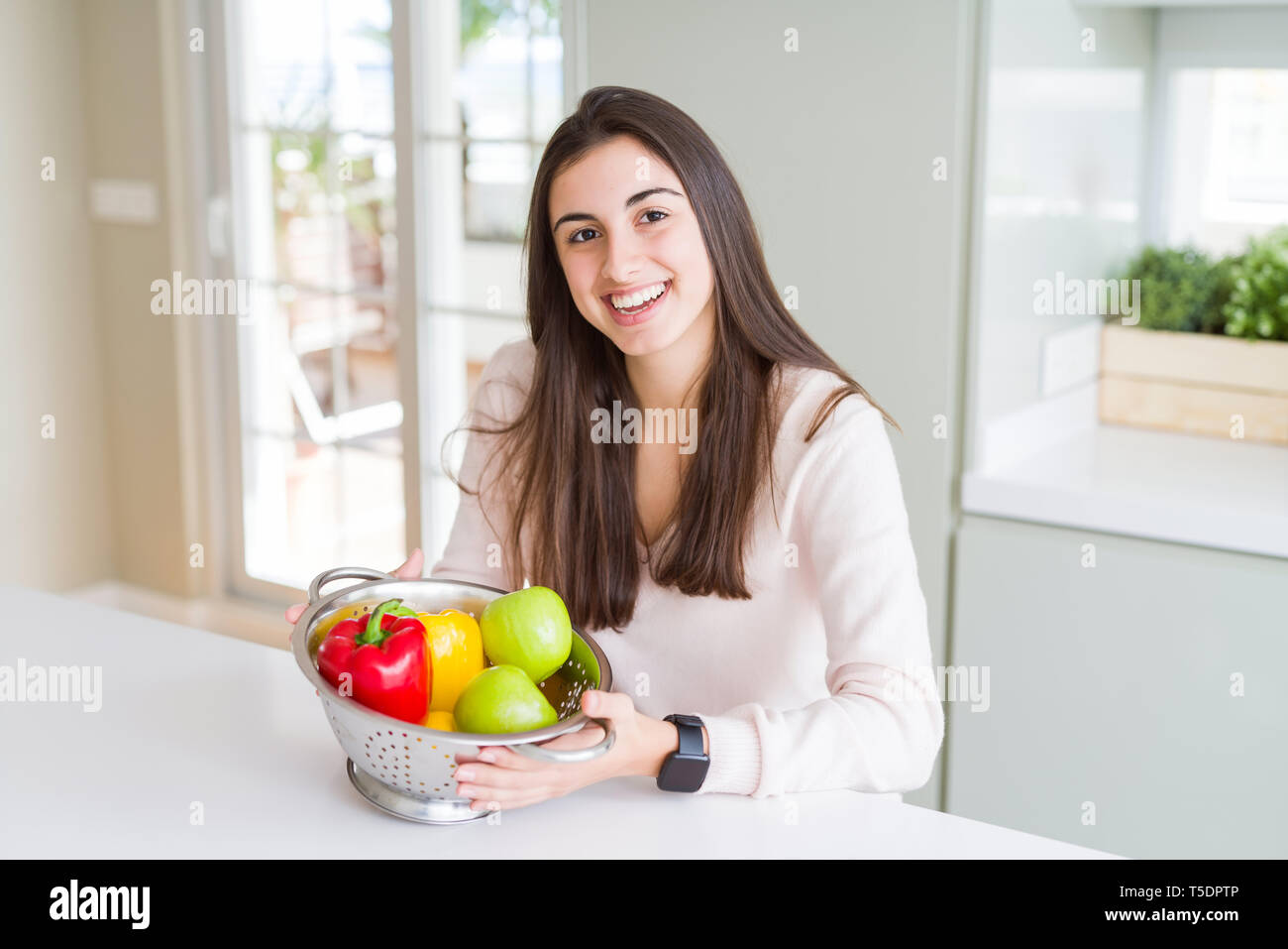 Beautiful young woman using colander to wash and clean vegatables with ...