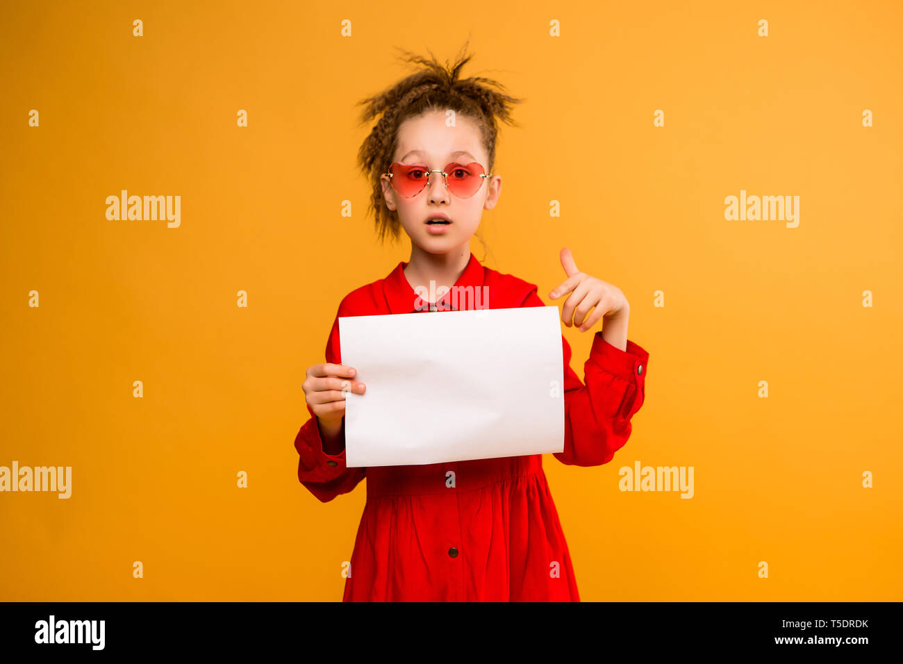 girl holding white sheet.Cute little girl with white sheet of paper ...