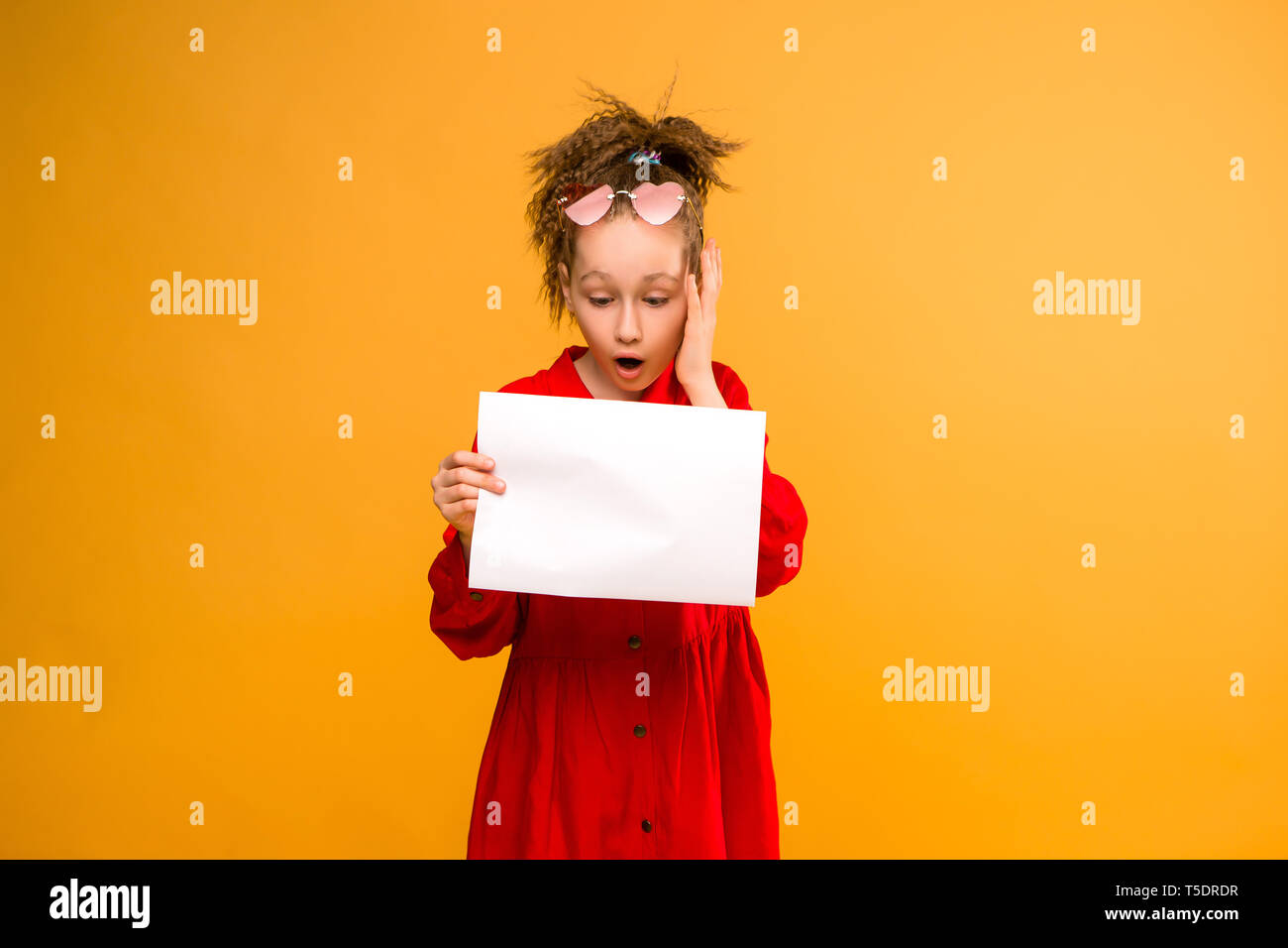 girl holding white sheet.Cute little girl with white sheet of paper ...