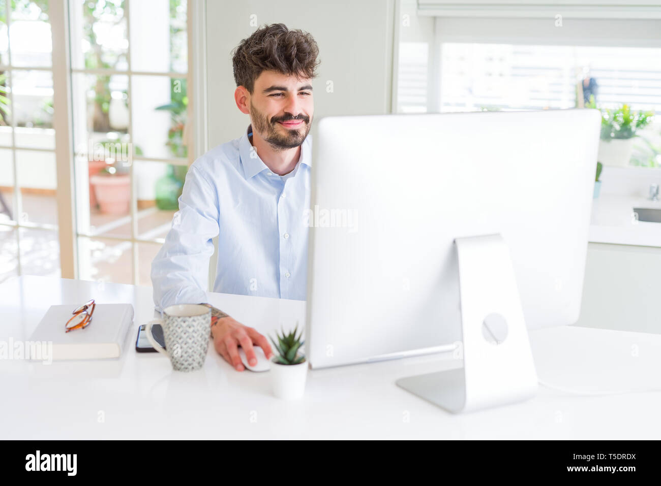 Handsome business young man working using computer, smiling confident ...
