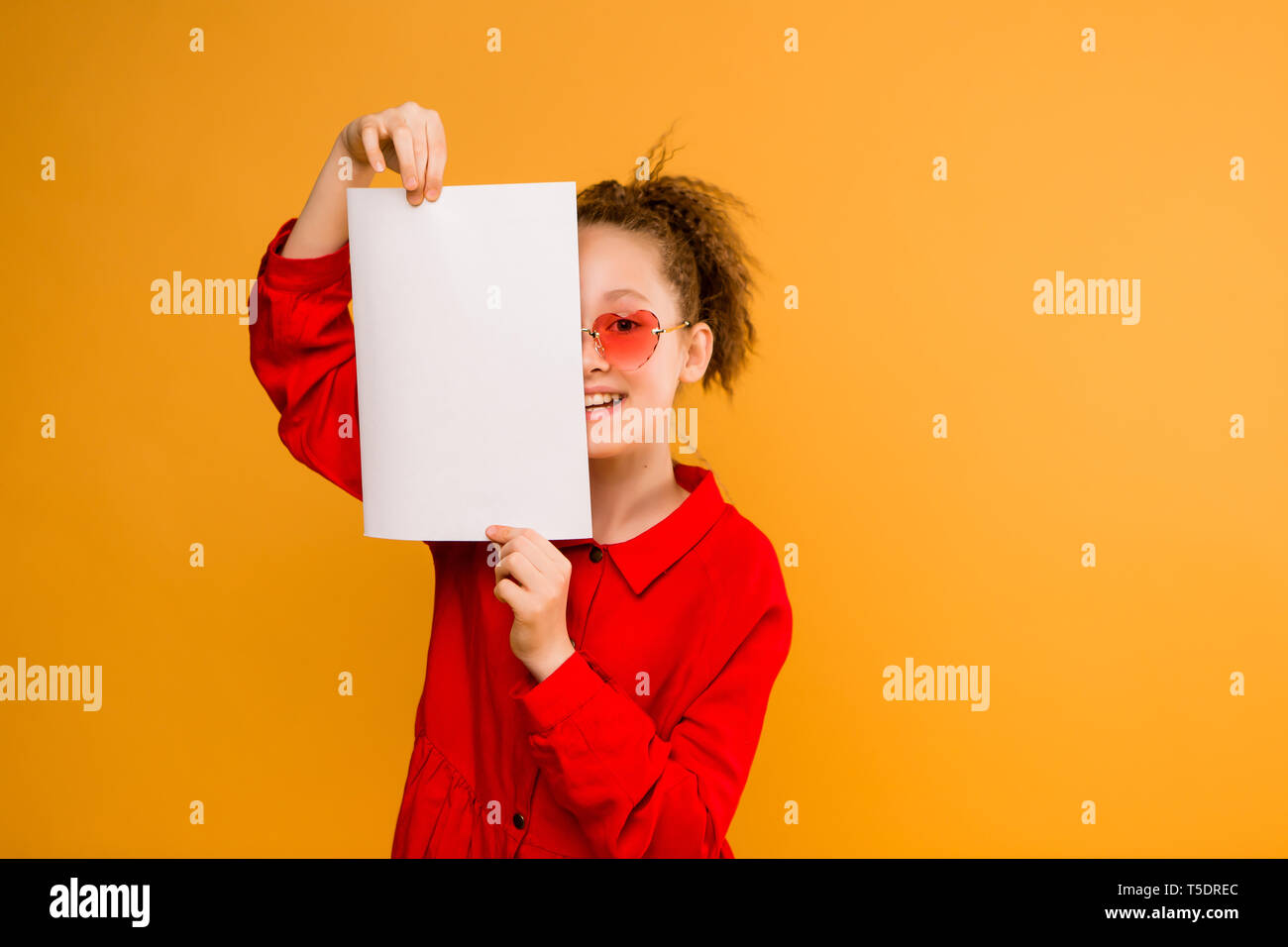 girl holding white sheet.Cute little girl with white sheet of paper ...