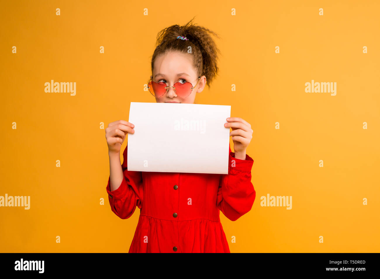 girl holding white sheet.Cute little girl with white sheet of paper ...