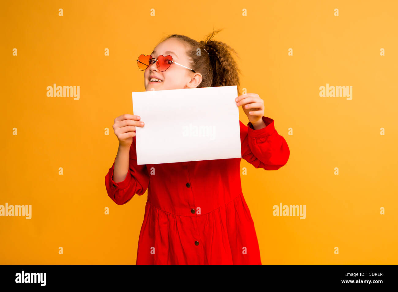 girl holding white sheet.Cute little girl with white sheet of paper ...