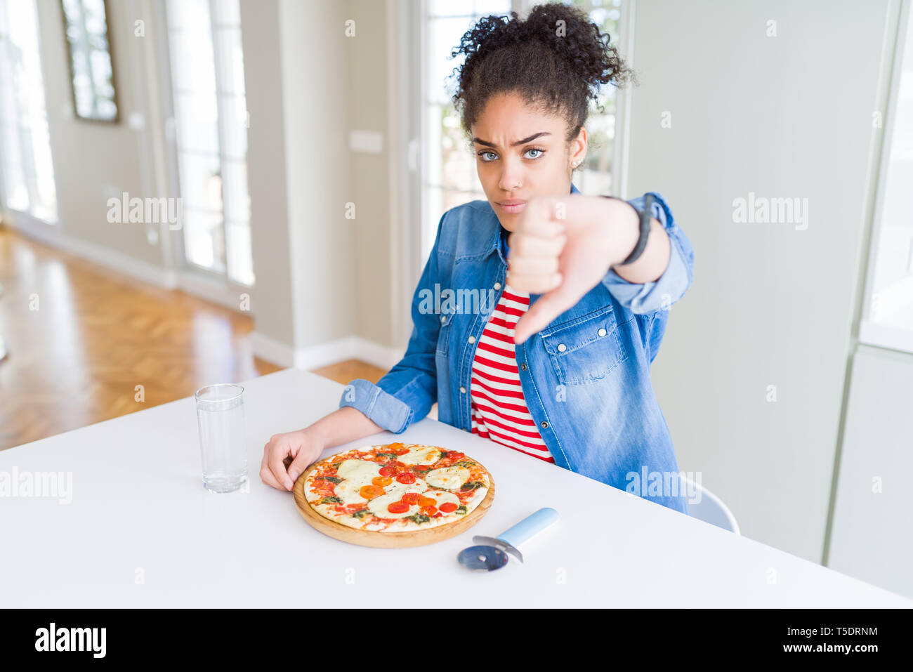 Young african american woman eating homemade mozzarella cheese pizza ...