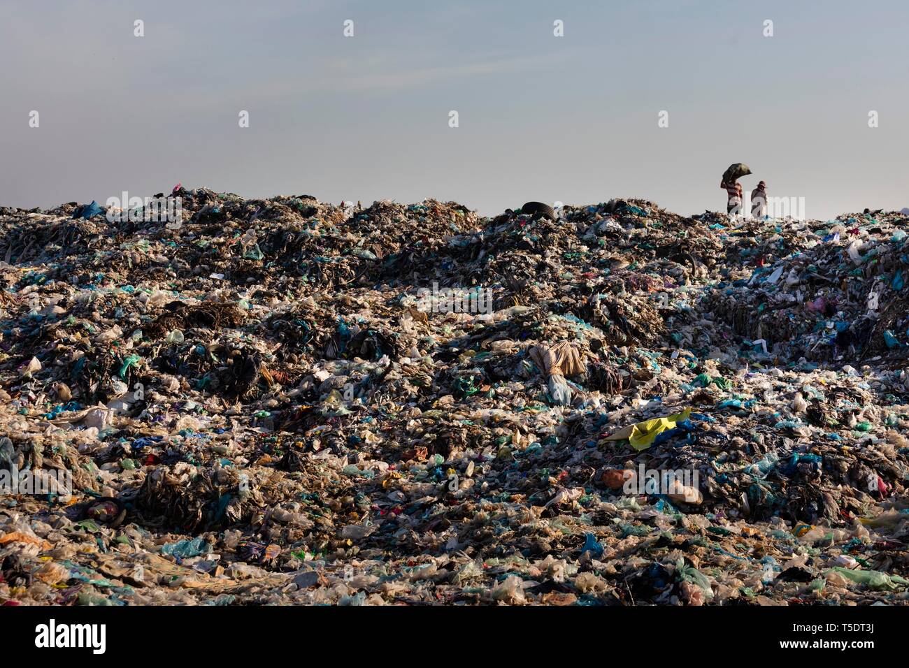 Garbage collector at garbage dump, garbage mountain with plastic ...