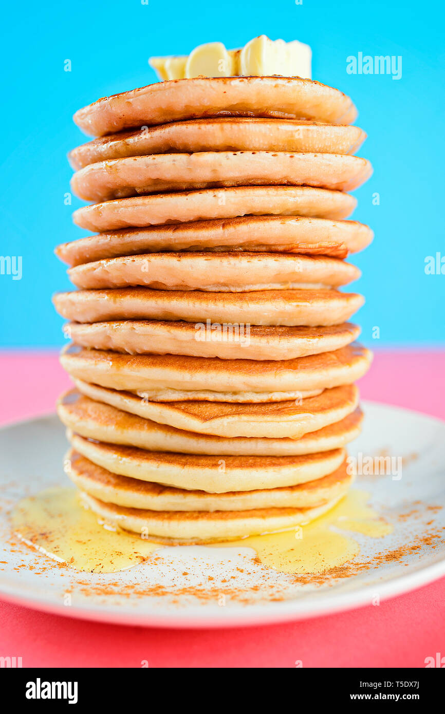 High stack of pancakes on pink and blue background Stock Photo - Alamy