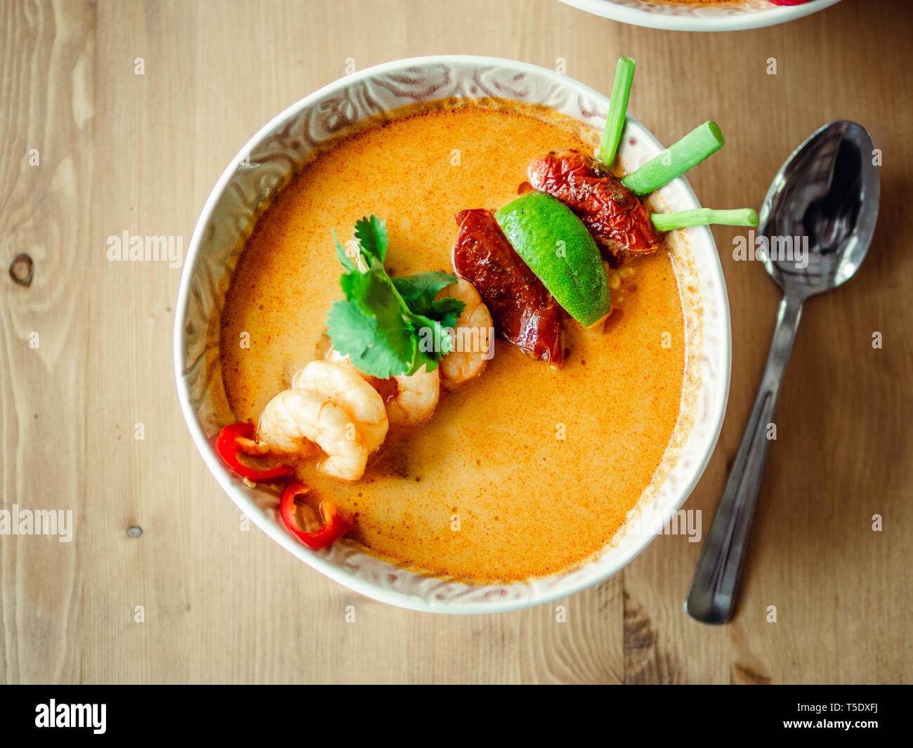 Tom yam kong ready-to-eat. Tom yum soup with shrimps on wooden table ...
