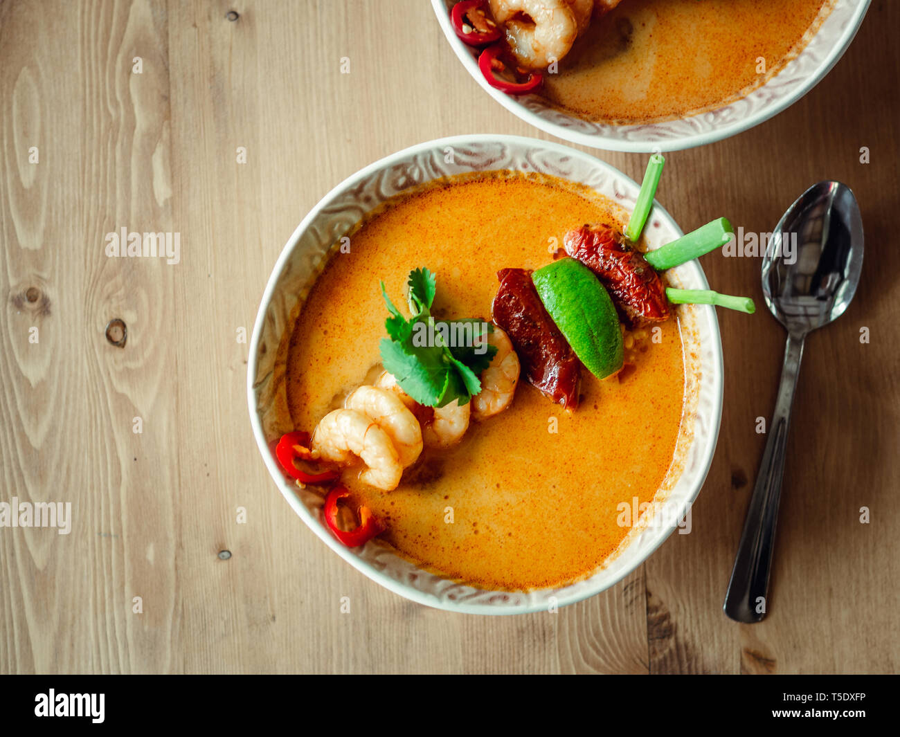 Tom yam kong ready-to-eat. Tom yum soup with shrimps on wooden table ...