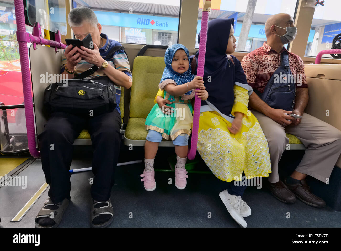 Ethnic Malay parents, Muslims, with child and an ethnic Chinese man ...