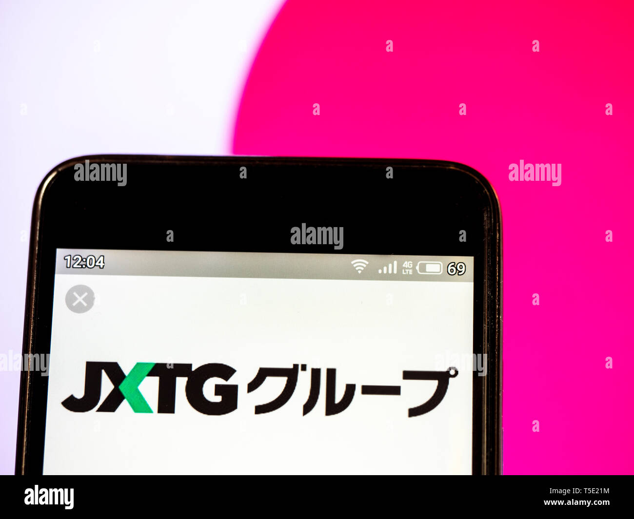 In this photo illustration a JXTG Holdings logo seen displayed on a ...