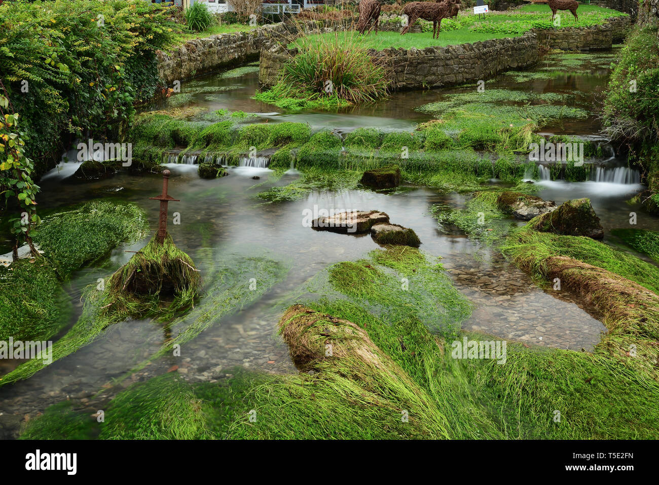 Long exposure of the river flowing past a sword sticking out of the ...