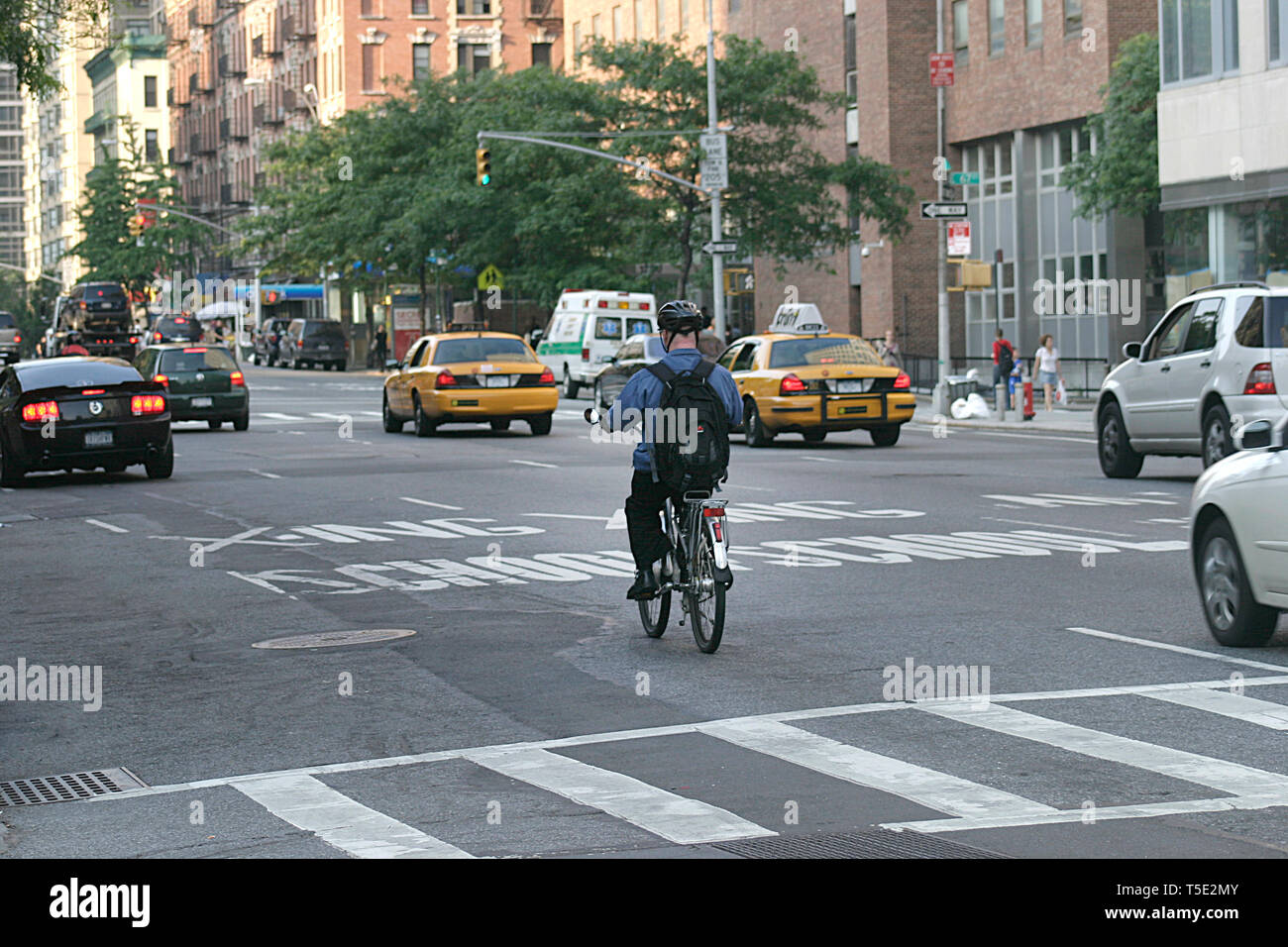 Man riding a bicycle through traffic in Manhattan, New York, USA Stock ...