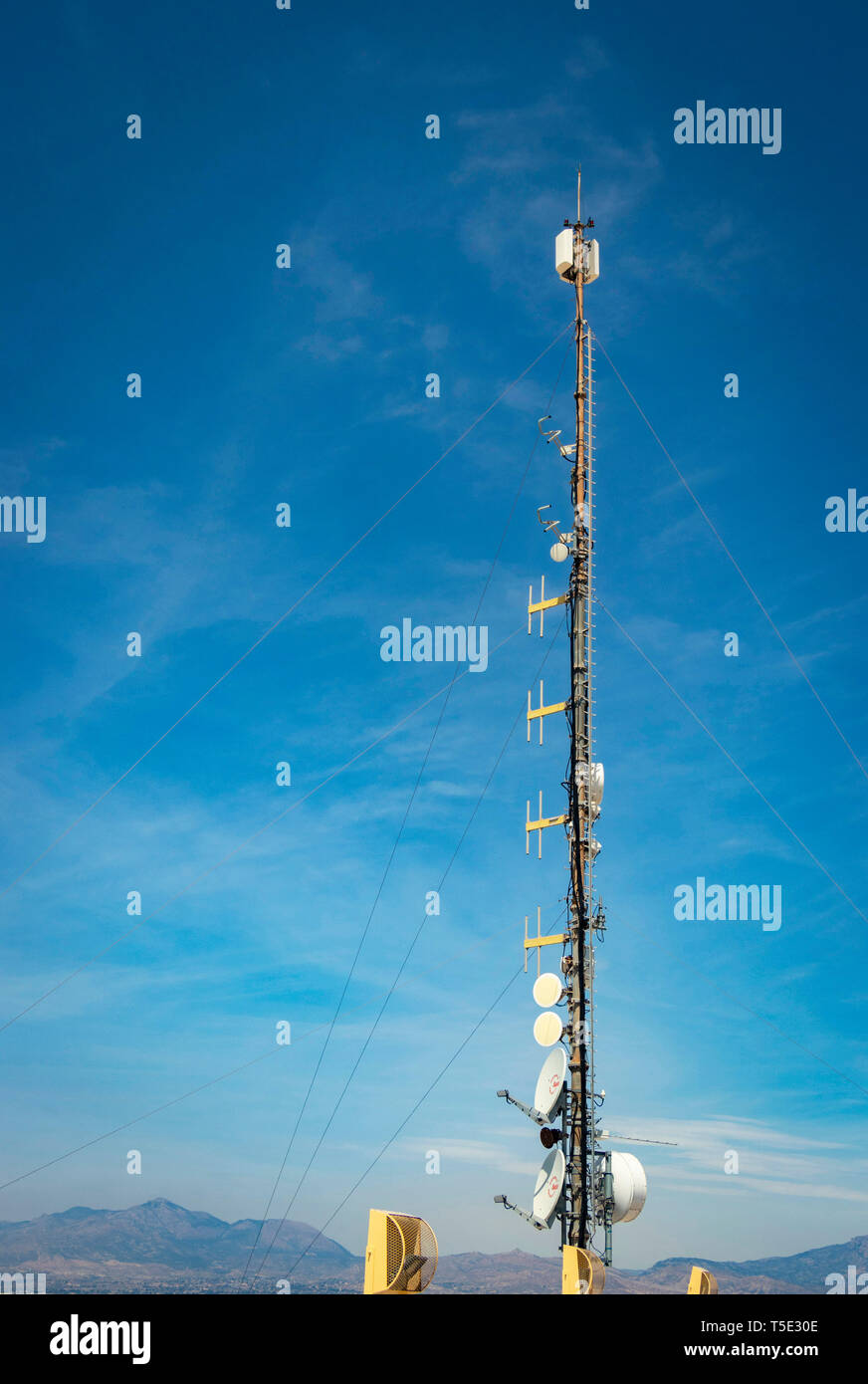 communications mast with array of aerials, dishes and cell transmitter ...
