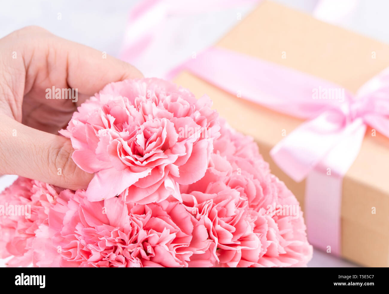 Design concept - Woman giving carnations bouquet on marble white ...