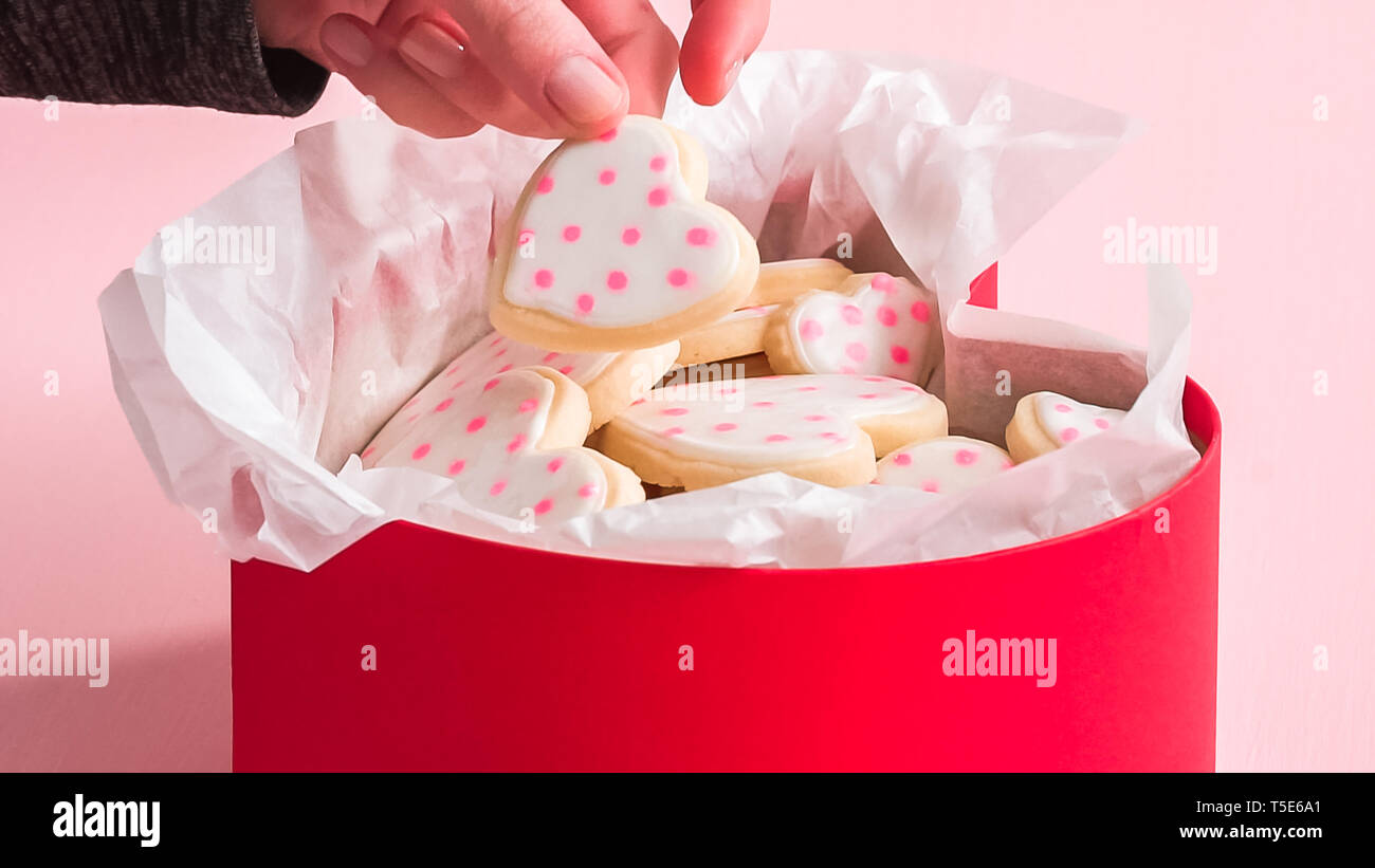 Packing heart shaped sugar cookies decorated with royal icing into the ...