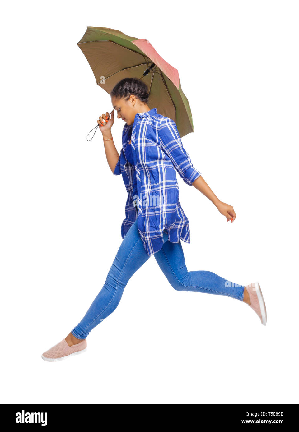 Side view of a woman balancing with an umbrella. girl jumps over a ...