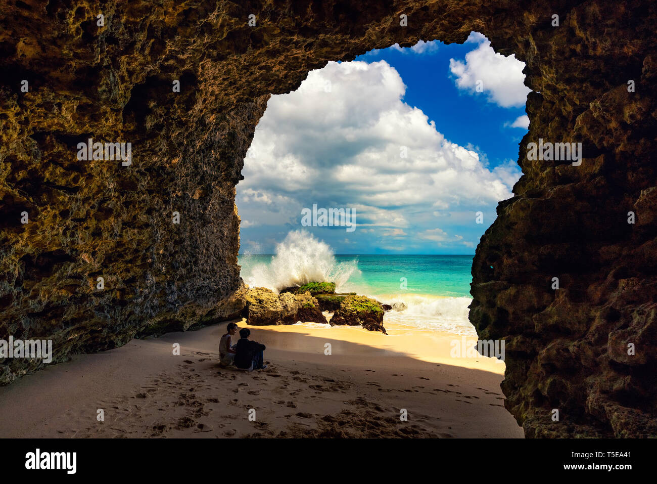 Indonesian couple in love sit in a cave on the tropical beach on ...