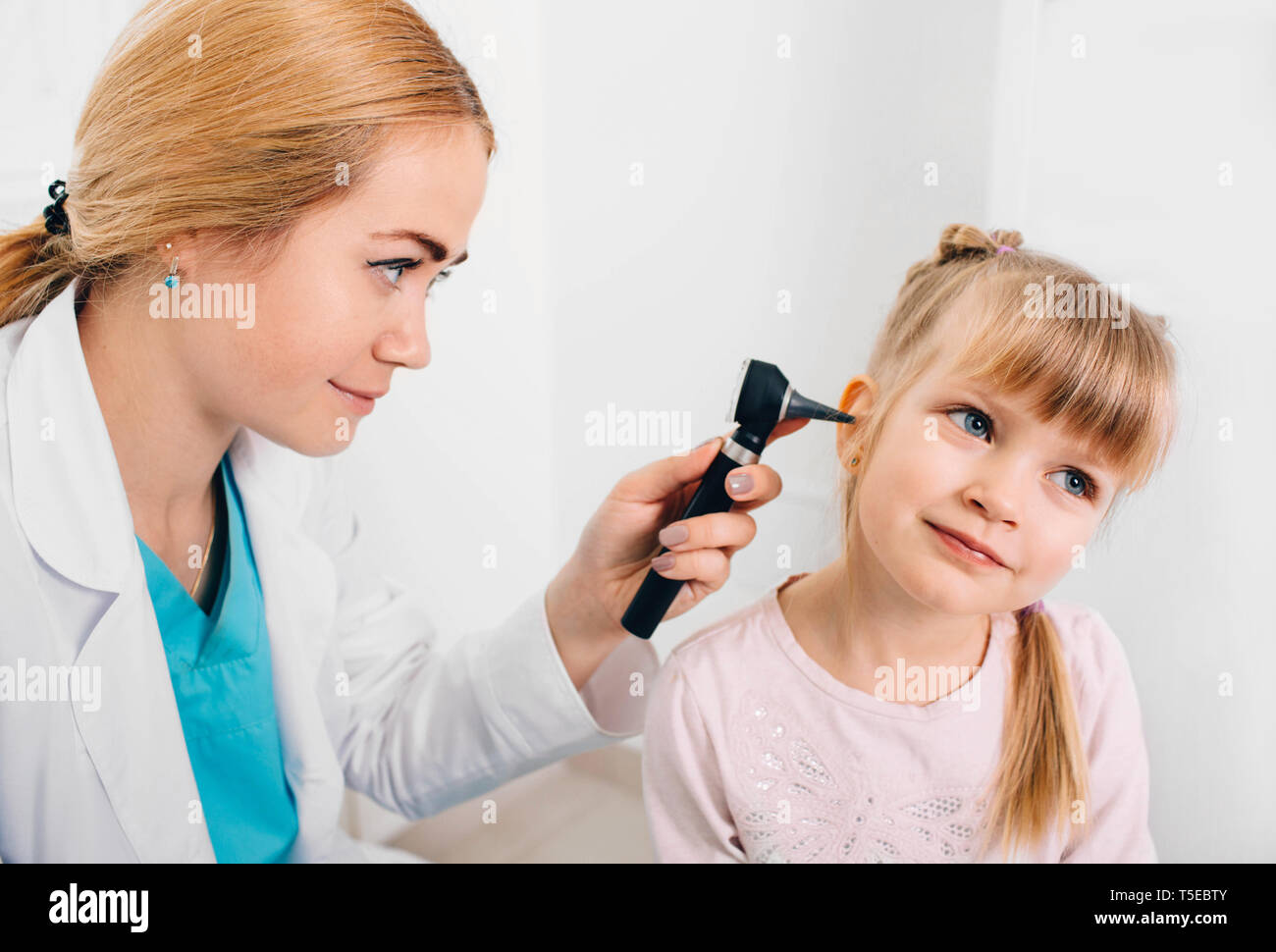 Smiling little girl having ear exam with otoscope Stock Photo - Alamy