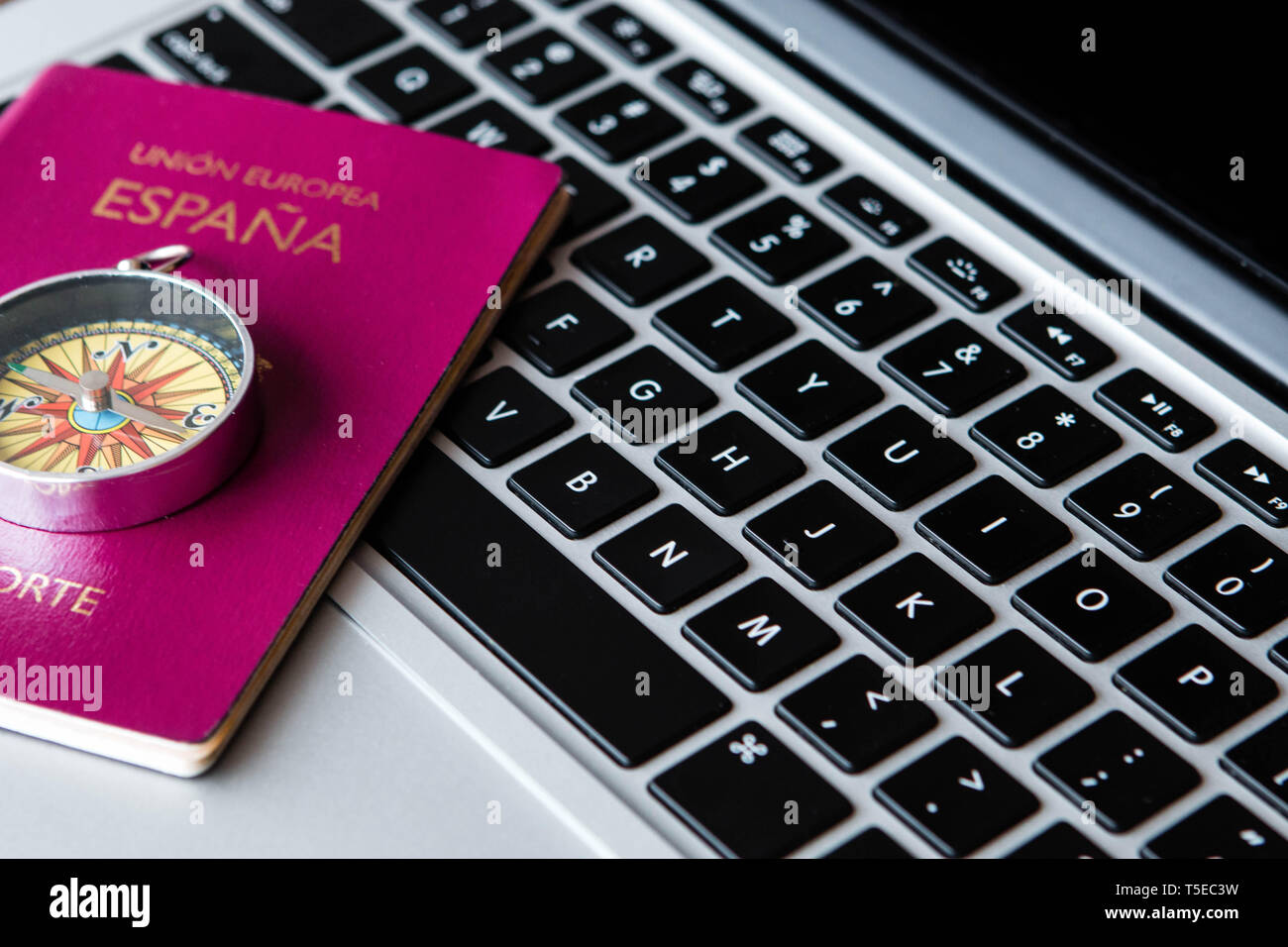 Compass and passport on a keyboard. Traveling around the world concept ...