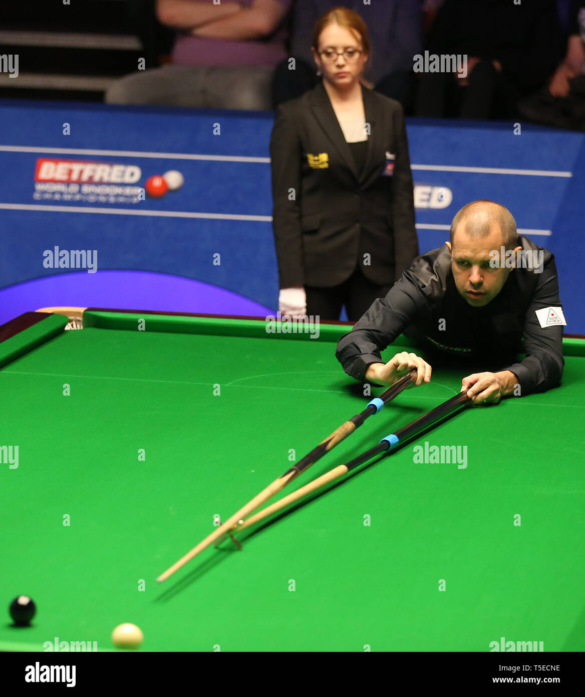Barry Hawkins plays a shot as referee Desislava Bozhilova looks on ...