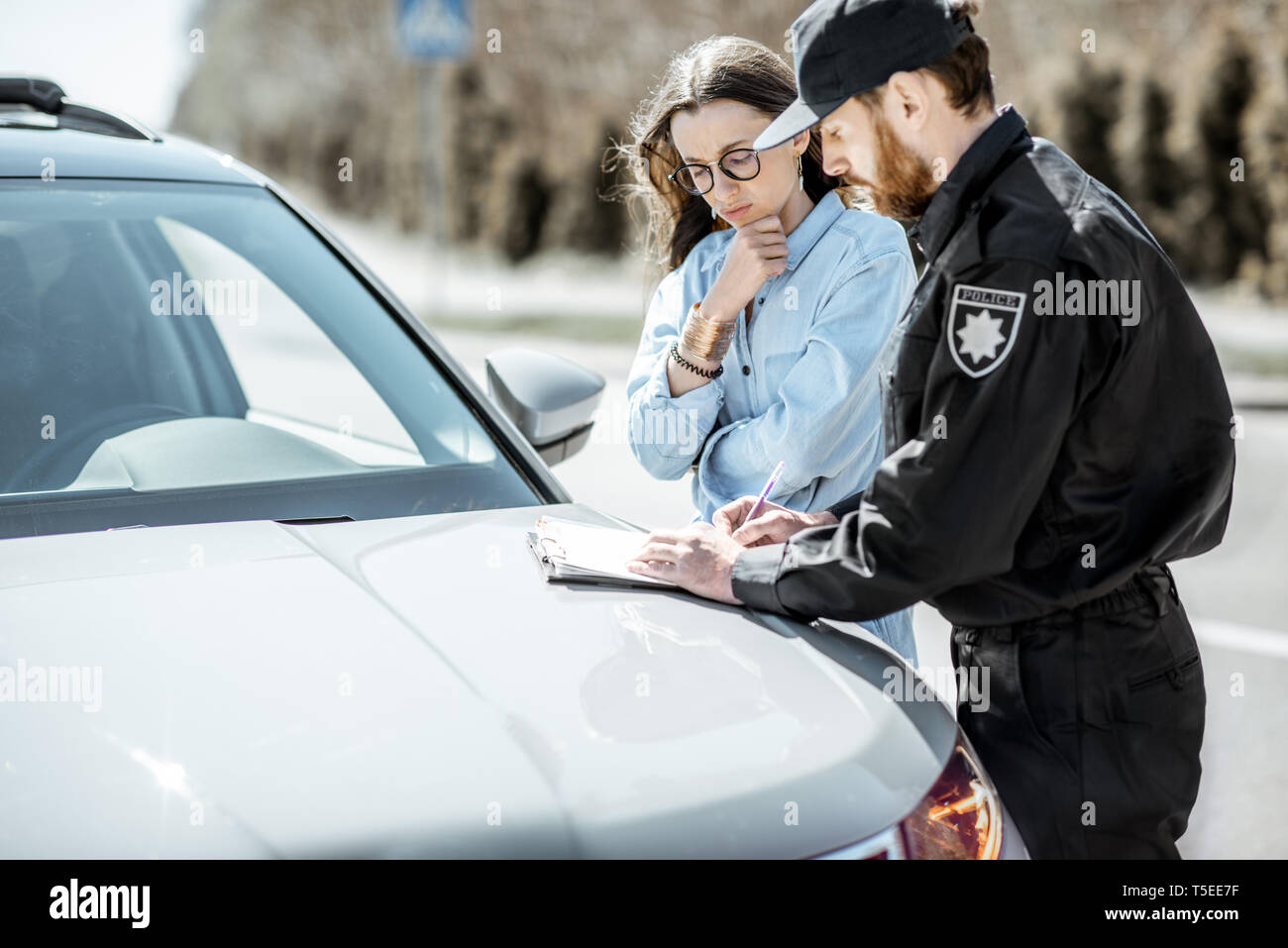 Policeman issuing a fine for violating the traffic rules to a young ...