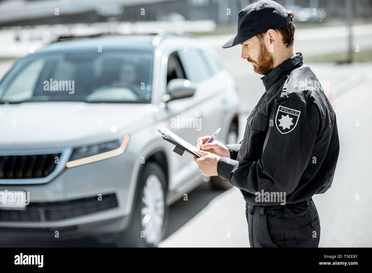 Policeman issuing a fine for violating the traffic rules standing in ...