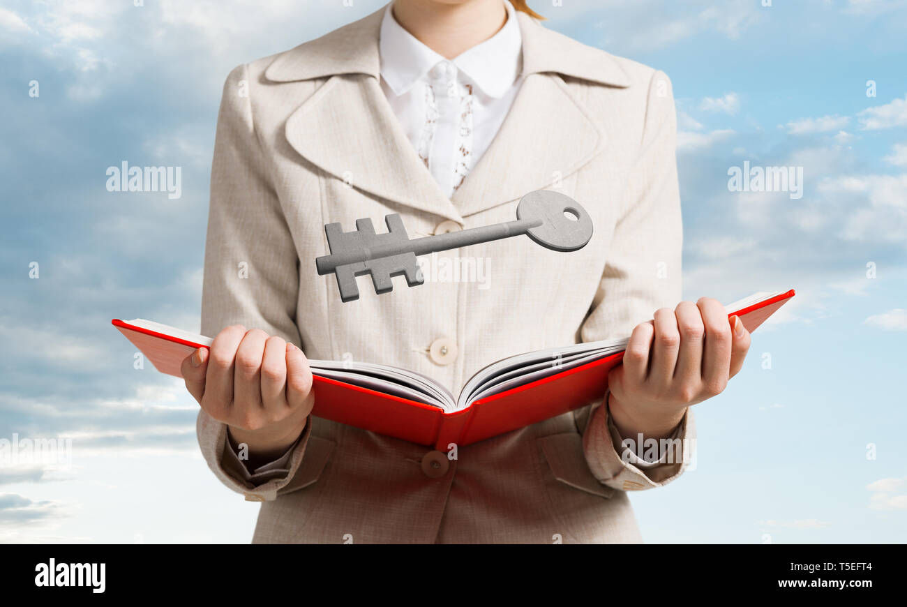 Woman showing big metal key Stock Photo - Alamy
