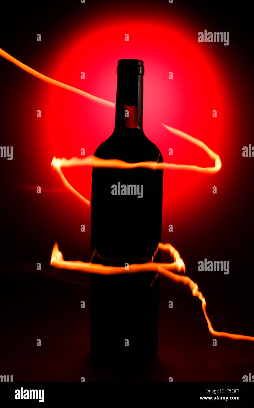 Bottle of wine on the red background with flames Stock Photo - Alamy
