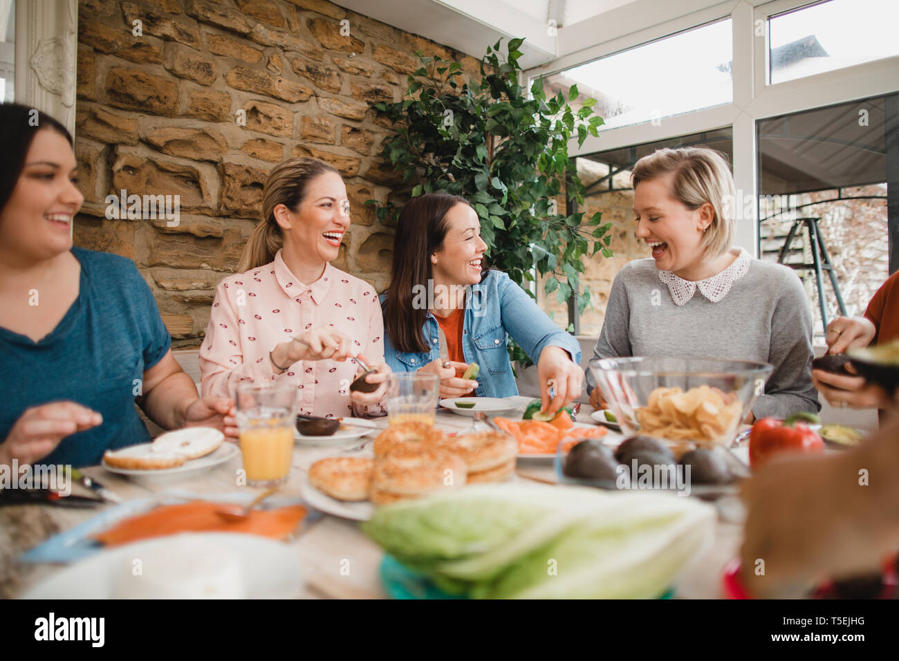Small group of female friends preparing a healthy lunch inside of a ...