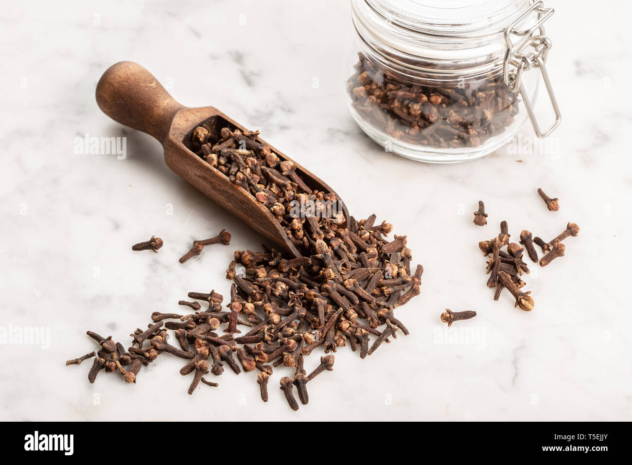 Spice cloves and wooden scoop on marble table. Syzygium aromaticum ...