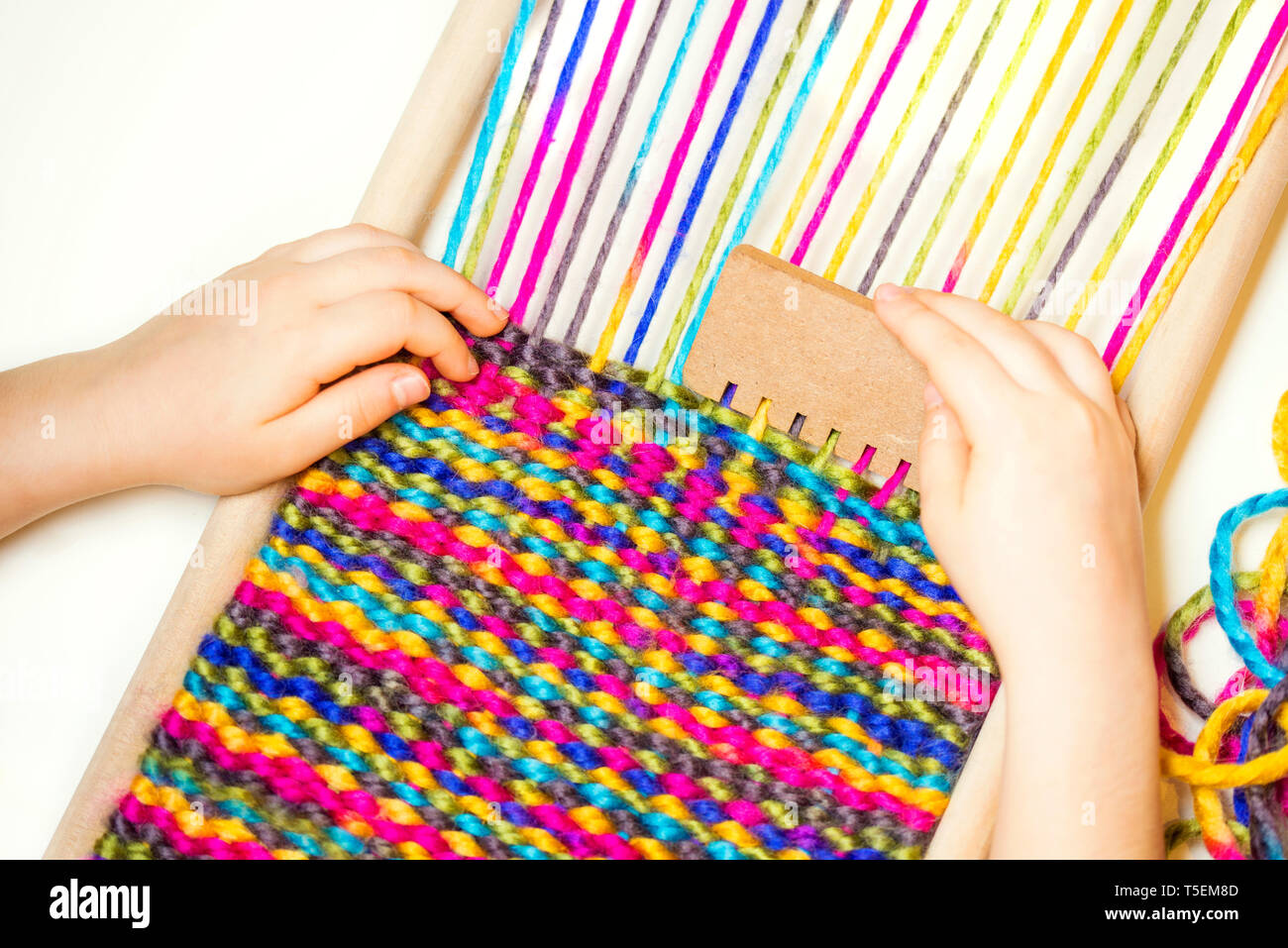Weaving. Hands of little caucasian girl working on small loom weaving ...