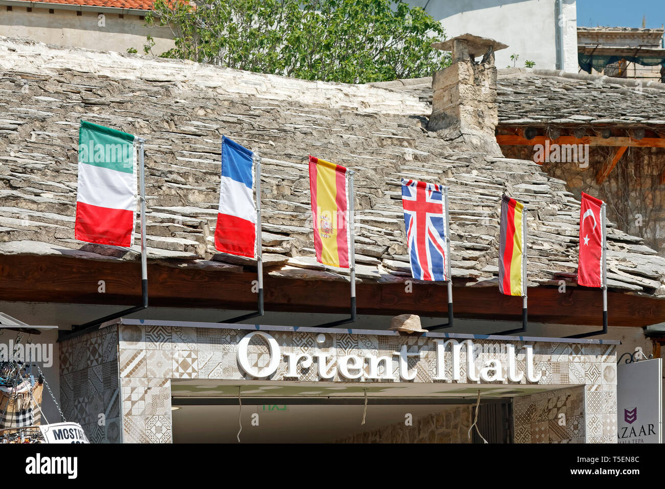 Orient Mall entrance, colorful country flags, old stone building, shops ...