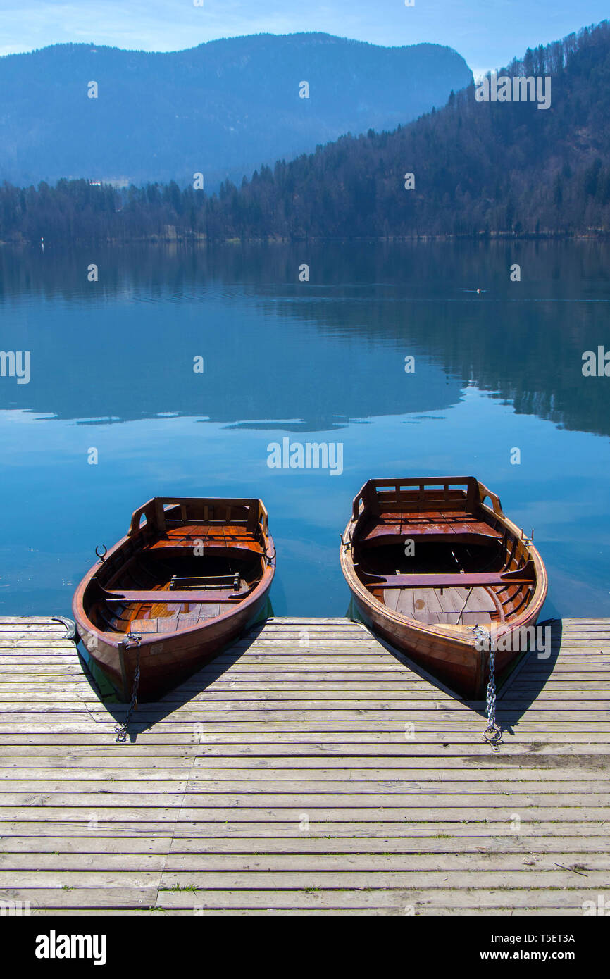 Boats on Lake Bled anchored to the dock Stock Photo - Alamy