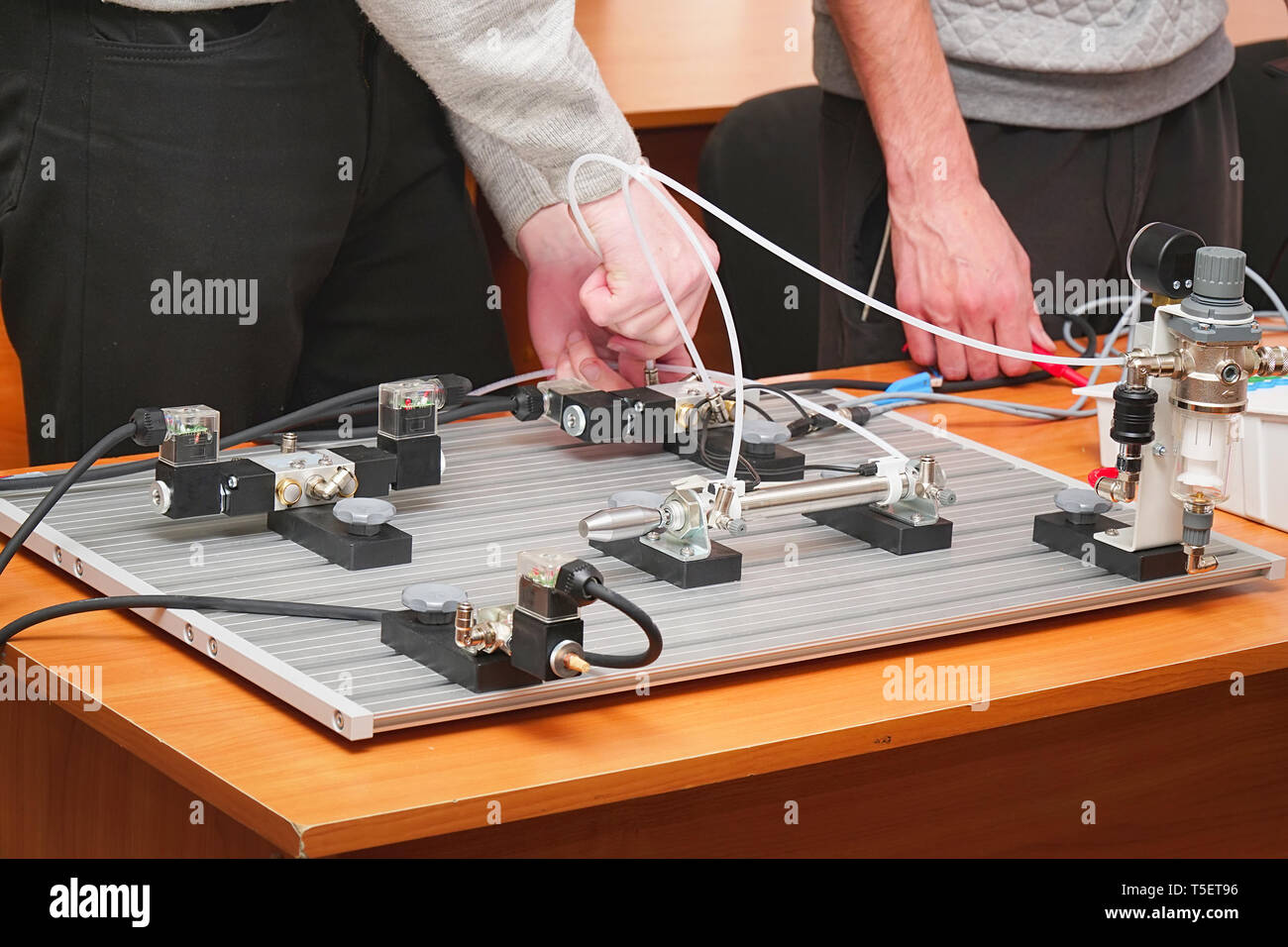 Engineers connect wires control panel with small test bench for ...