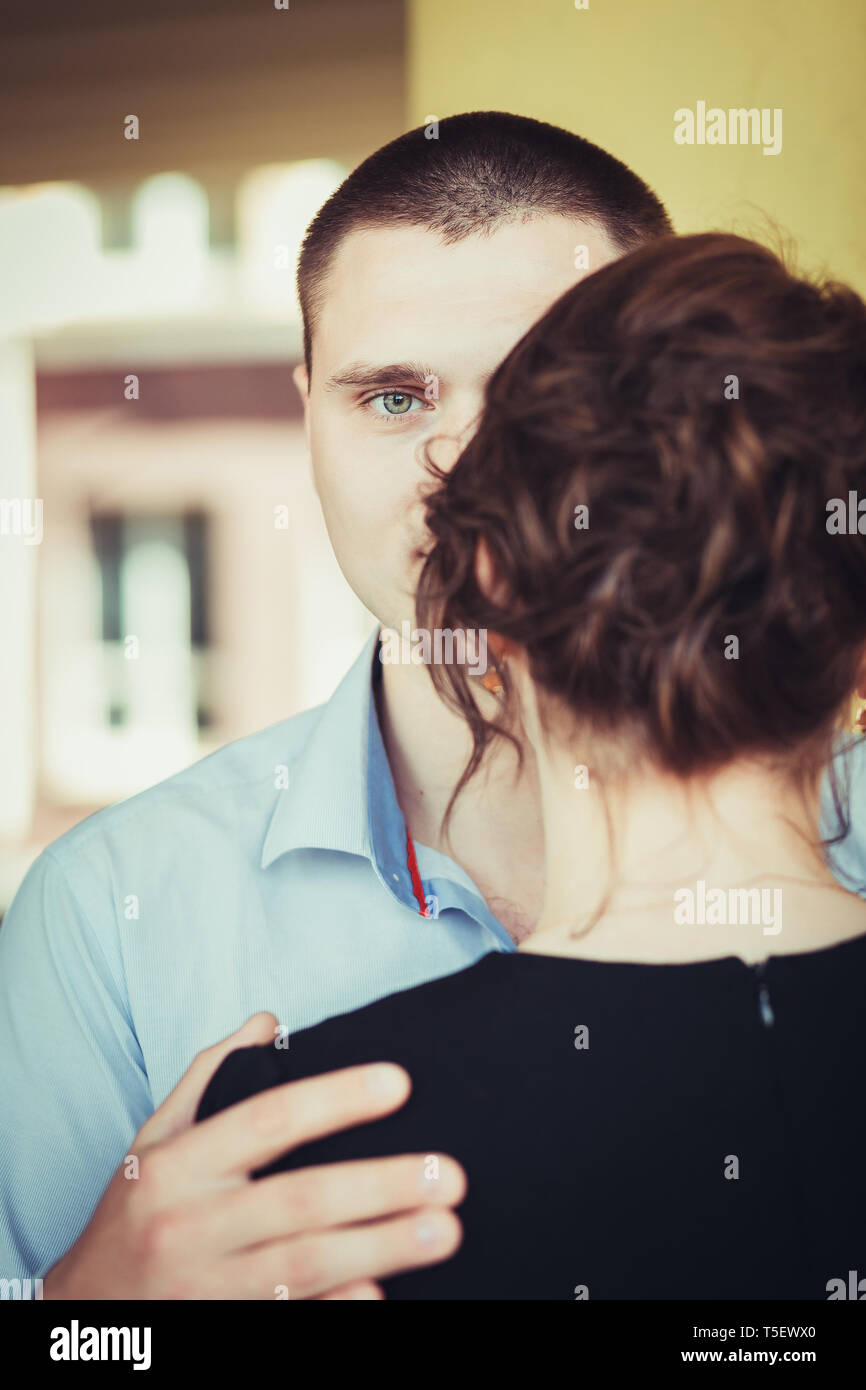 Portrait of young man looking from behind the shoulder of his ...