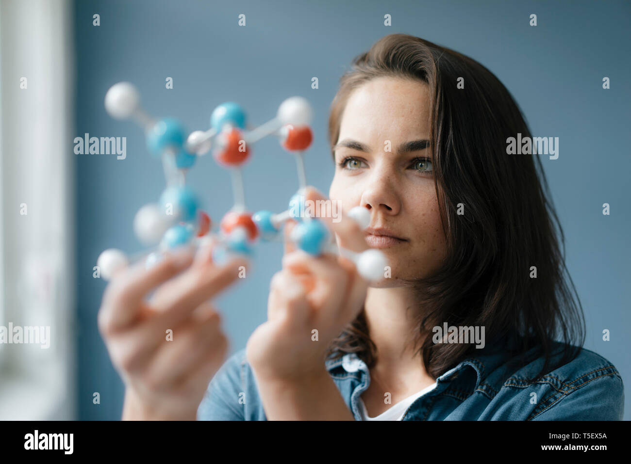 Female scientist studying molecule model, looking for solutions Stock ...