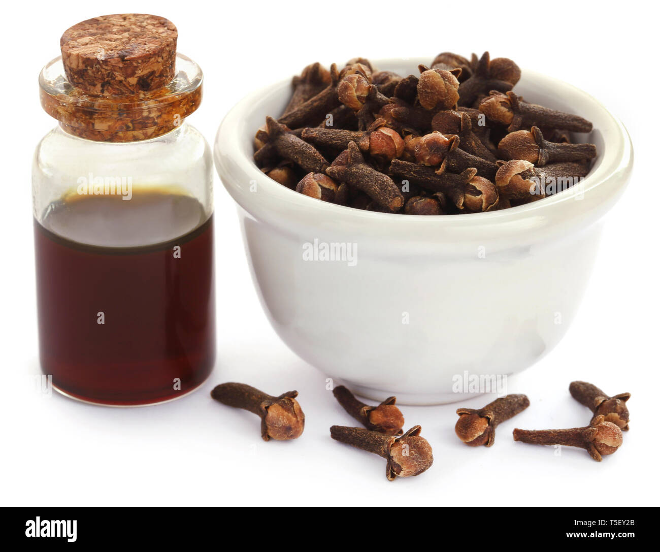 Fresh clove in bowl with oil in a jar over white background Stock Photo ...