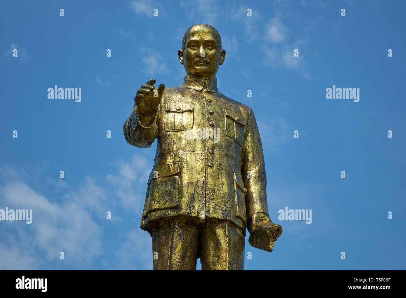 A standing, pointing, shiny gold statue of Chinese leader Chiang Kai ...