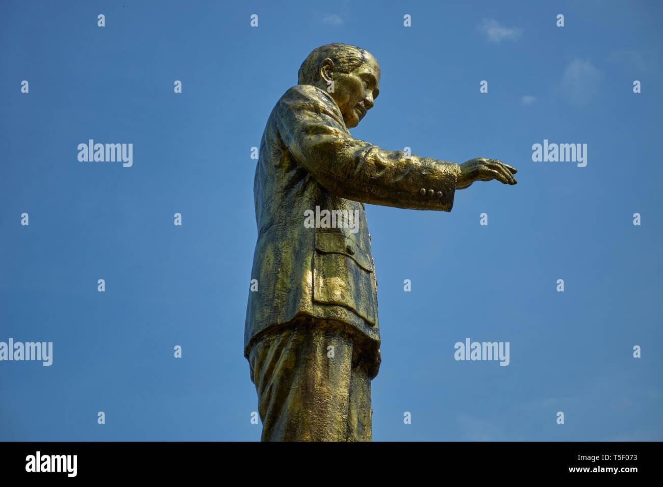 A standing, pointing, shiny gold statue of Chinese leader Chiang Kai ...