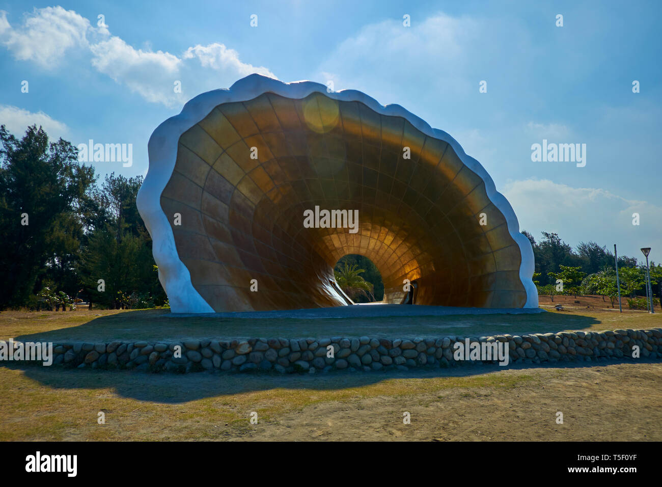 A large shell sculpture, shiny gold on the inside, whitewashed on the ...