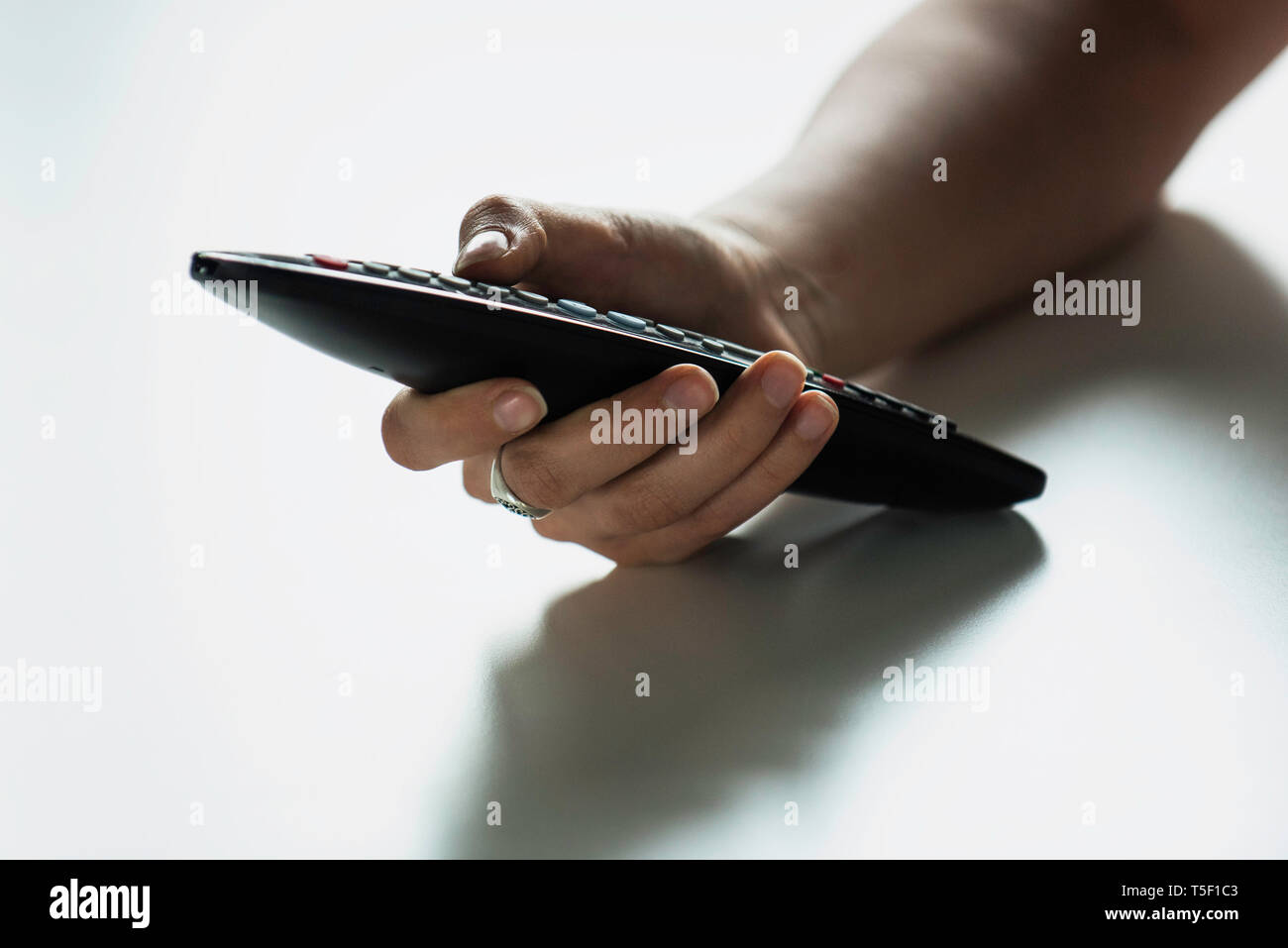 Hand holding remote control Stock Photo - Alamy