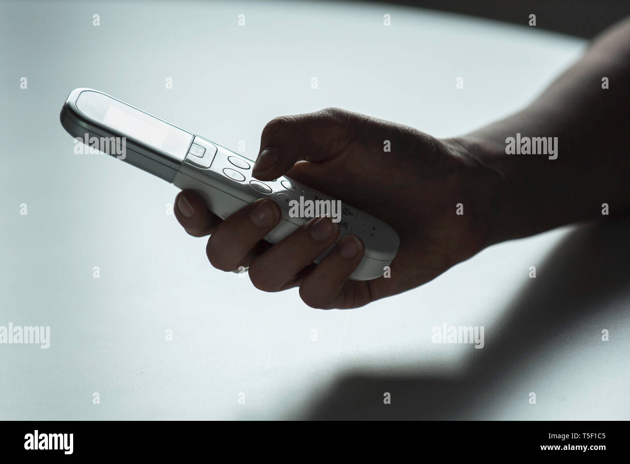 Hand holding AC remote control Stock Photo - Alamy