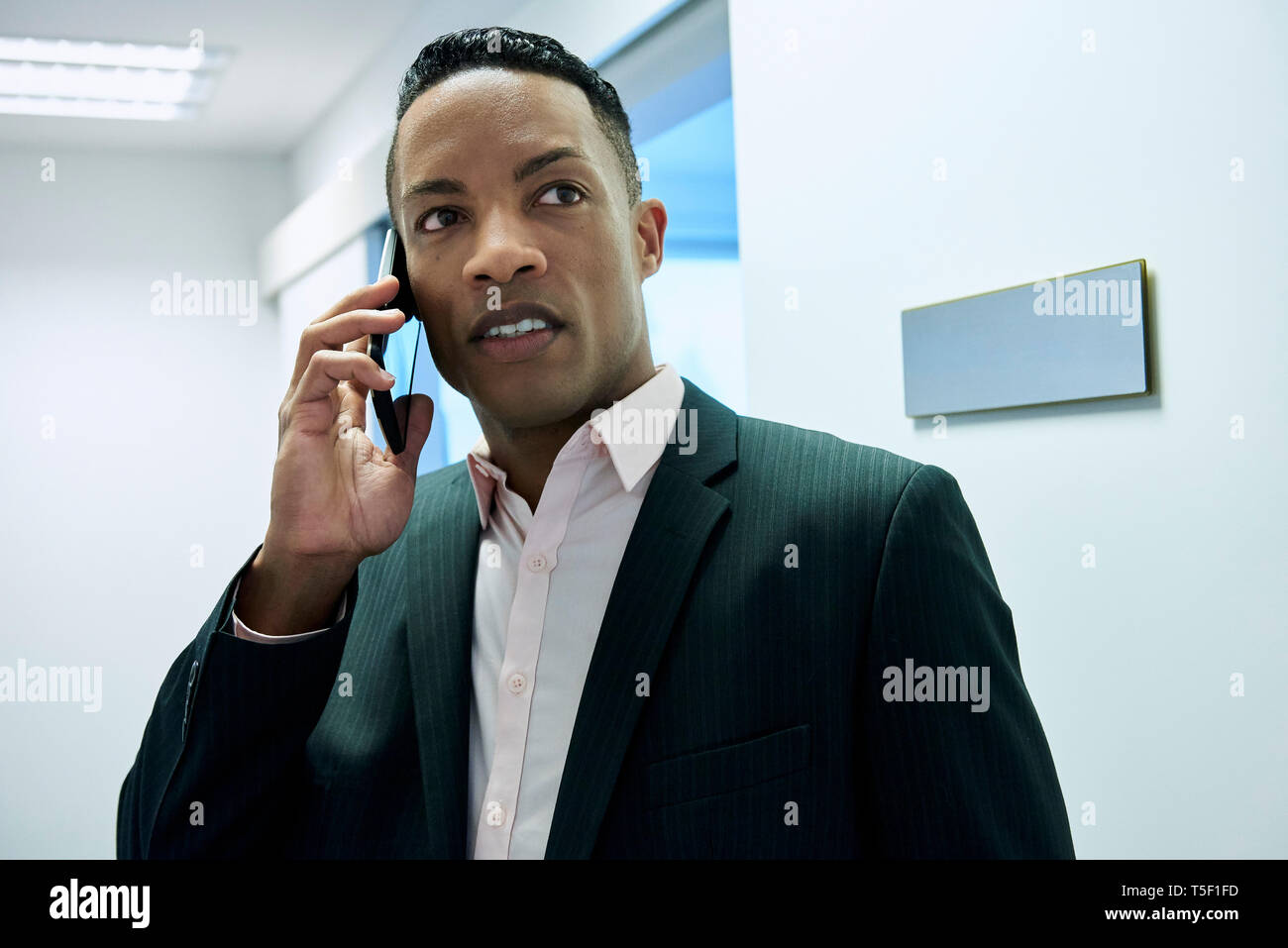 Businessman using smart phone in hotel lobby Stock Photo - Alamy