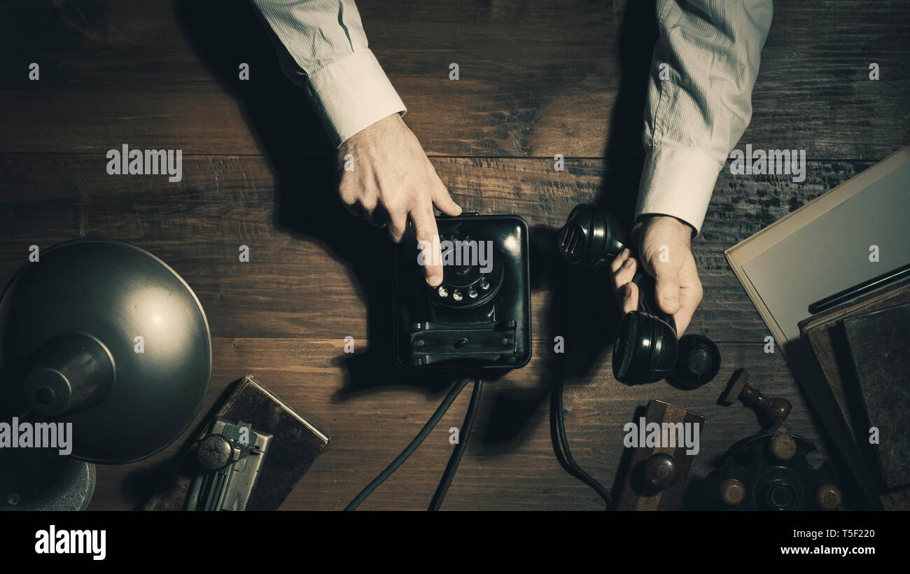 Businessman making a phone call late at night with a rotary dial ...