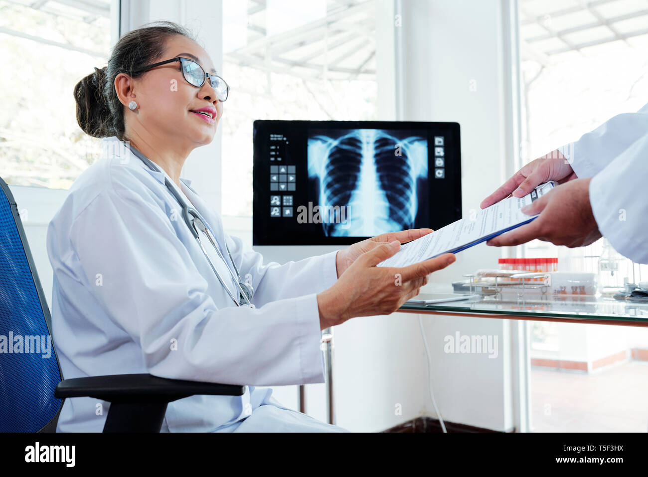 Female doctor taking medical report Stock Photo - Alamy