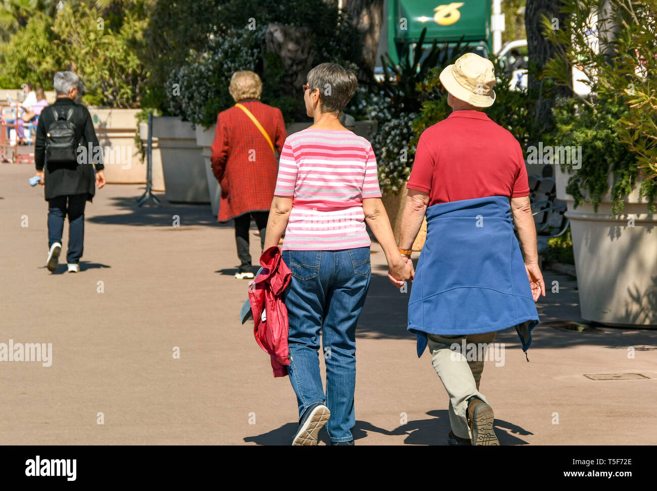 CANNES, FRANCE - APRIL 2019: Two people holding hands walking along the ...