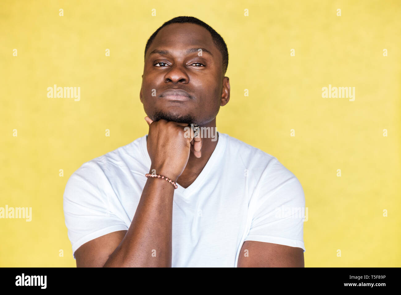 African american man put his chin on his hands and looks thoughtfully ...