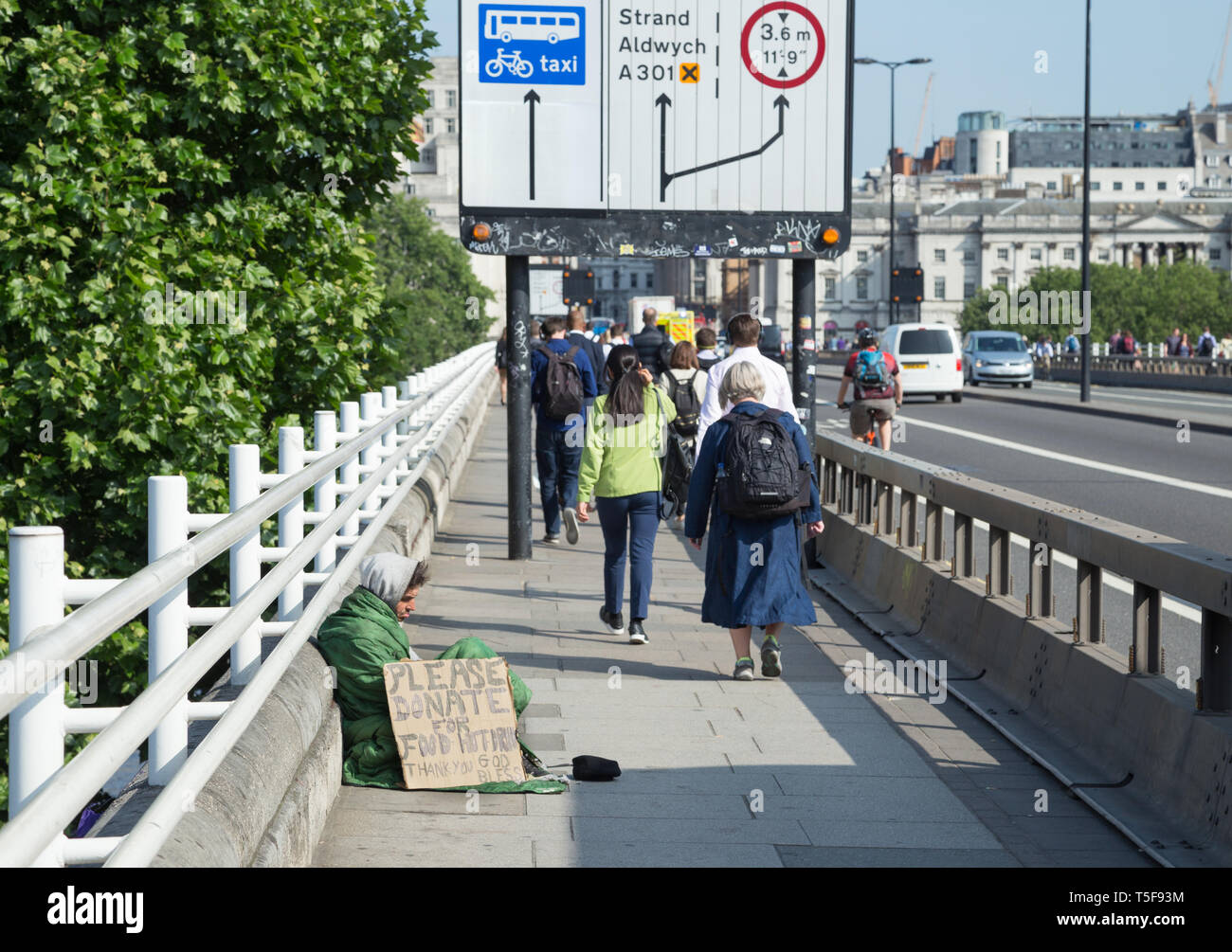 An apparently homeless man with a handwritten cardboard sign asking for ...